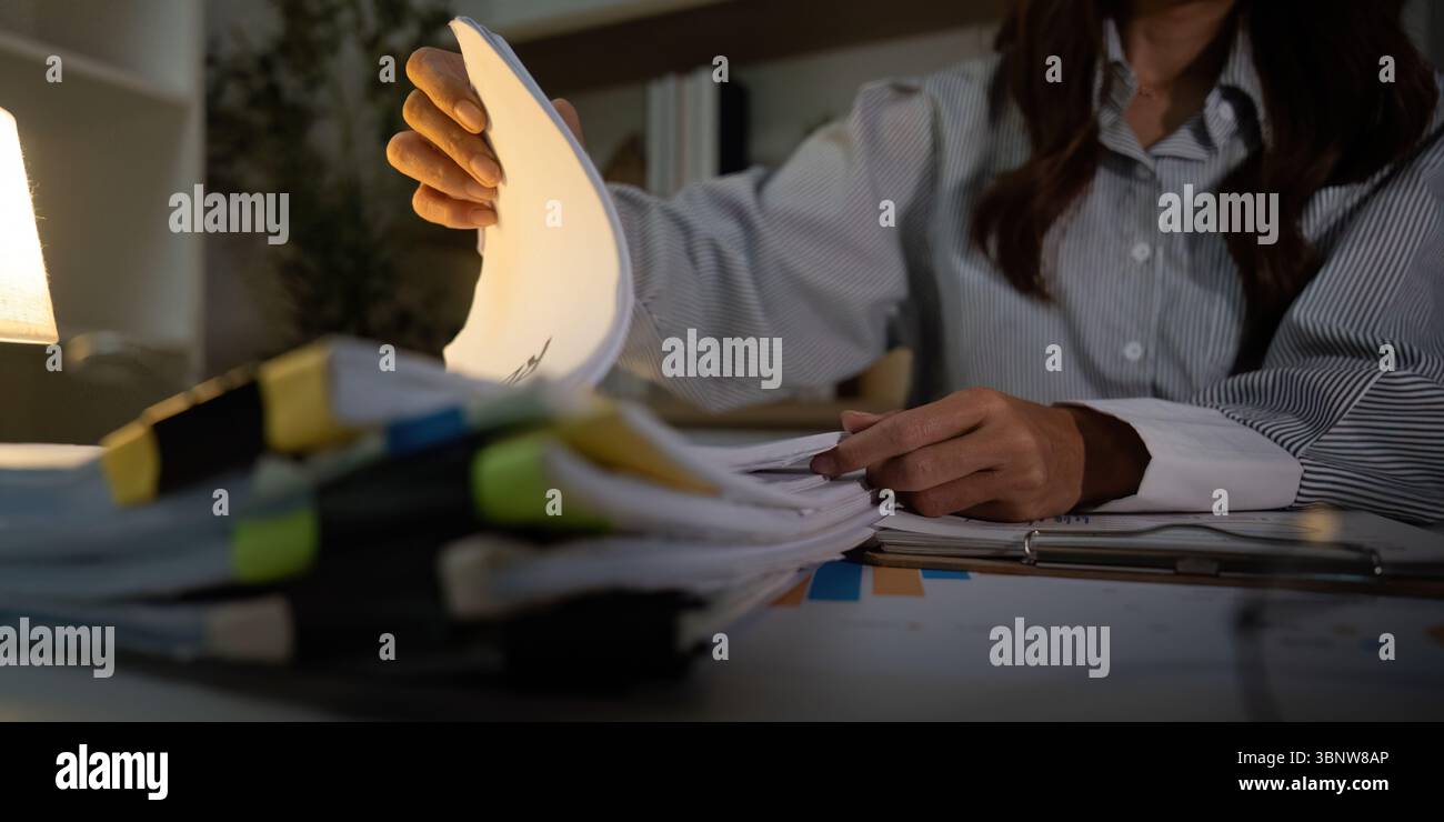 Late Night Paperwork. Close-up of hands sorting through documents in an ...