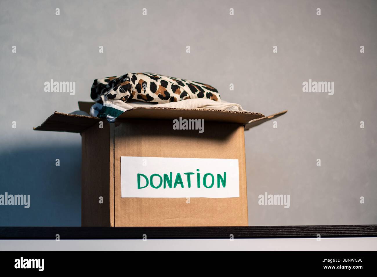 Cardboard box full of clothing ready for donation. Modern eco friendly ...