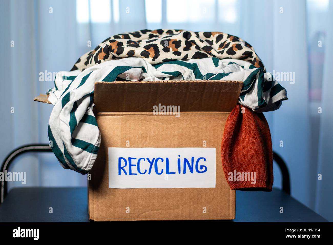 Cardboard box full of clothes labeled Recycling. Concept of sustainable ...