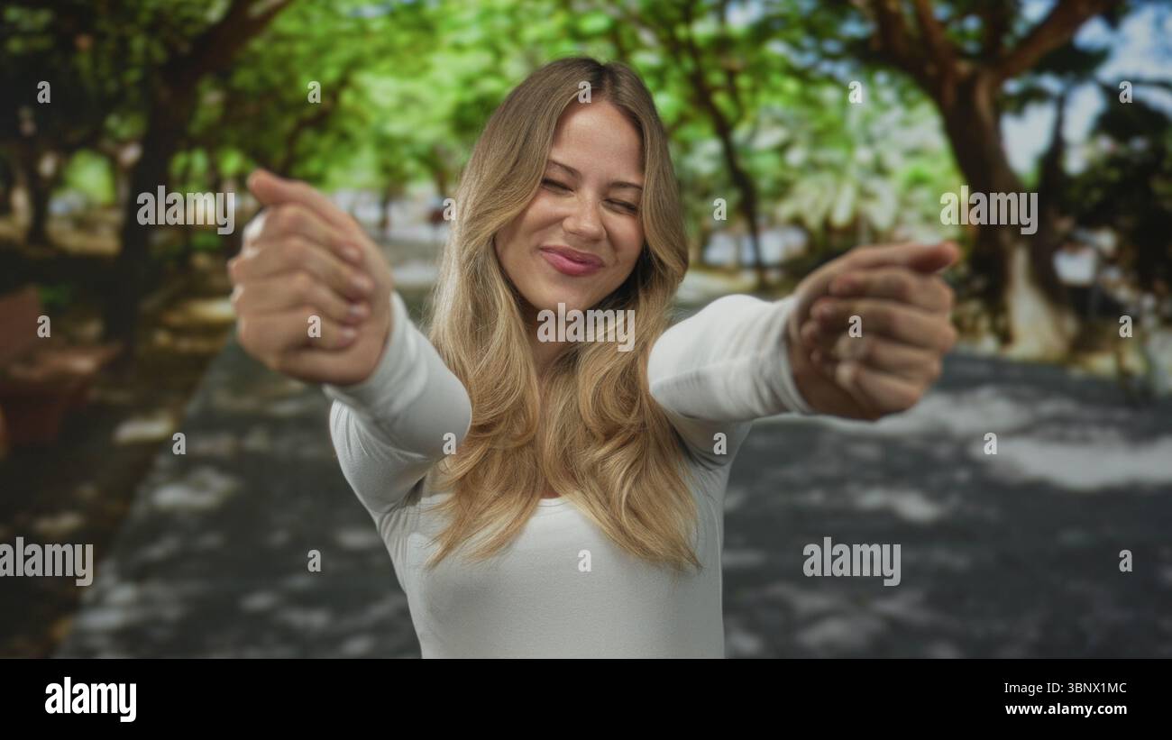 Blonde woman with eyes closed and gentle smile hugs her shoulders in ...