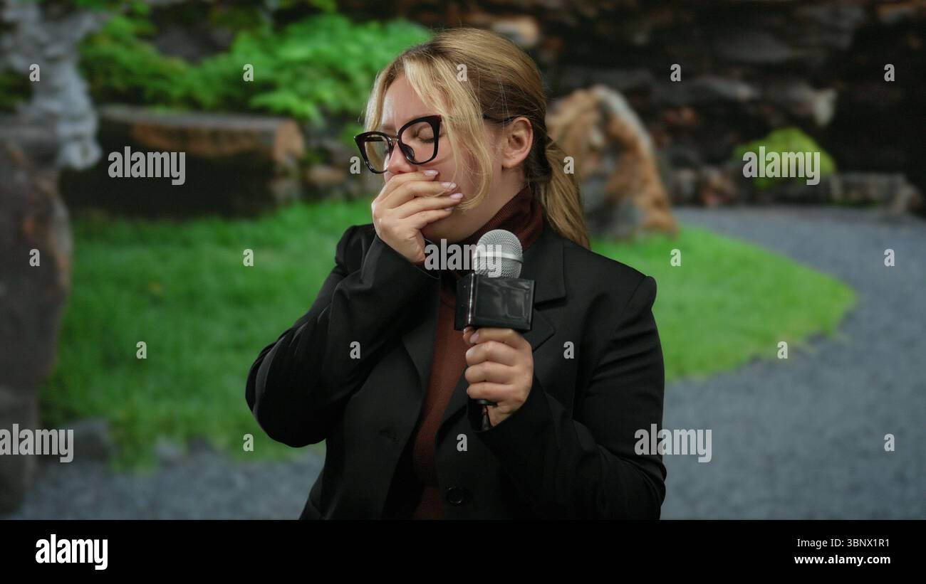 Woman reporter holding microphone appears emotional in an outdoor park ...