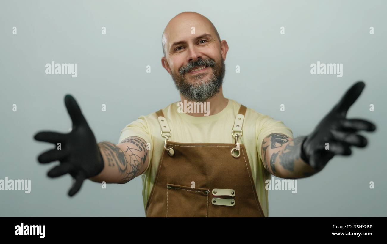 Bearded man in gloves and apron smiles offering a welcoming hug against ...