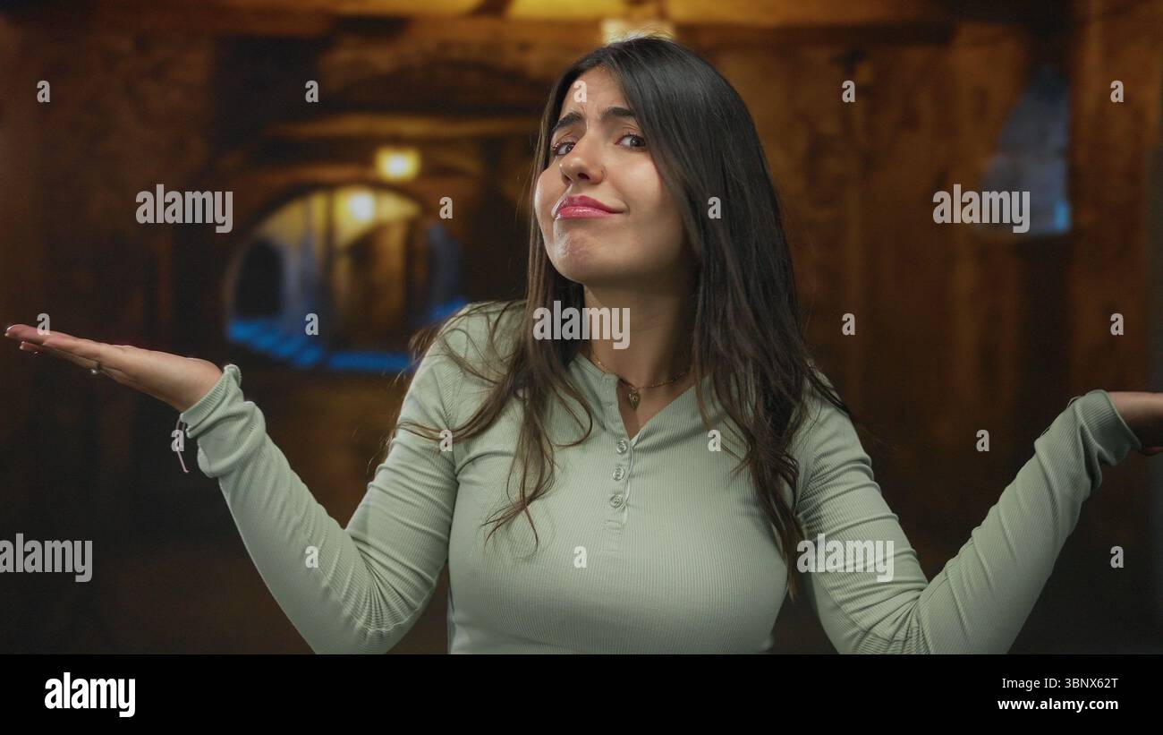 Young hispanic woman in outdoor alleyway, expressing confusion with ...