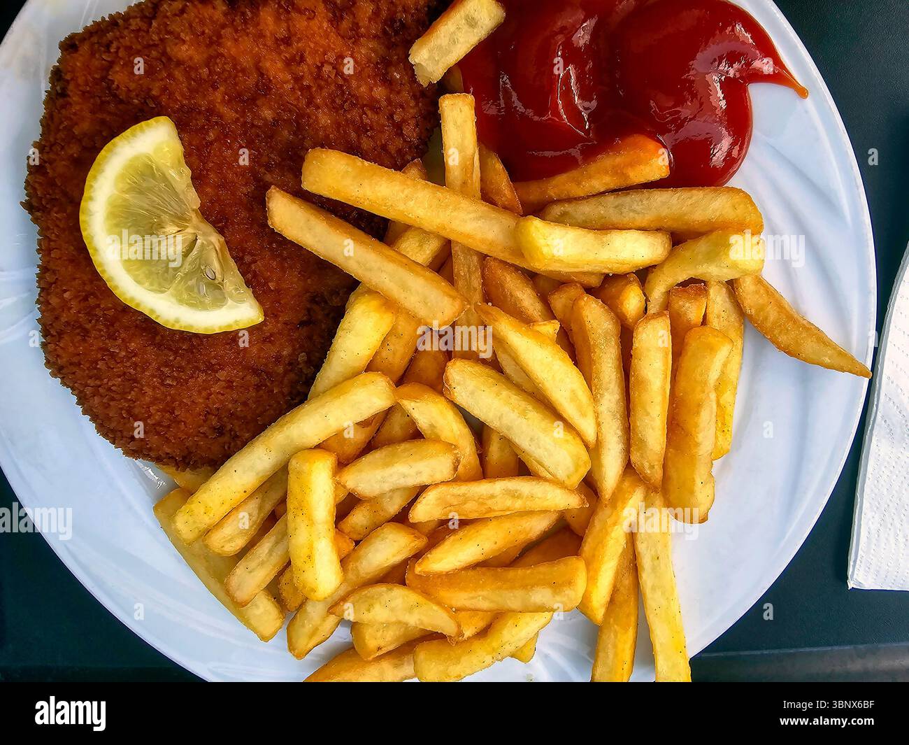 Wiener schnitzel with French fries and ketchup Stock Photo - Alamy
