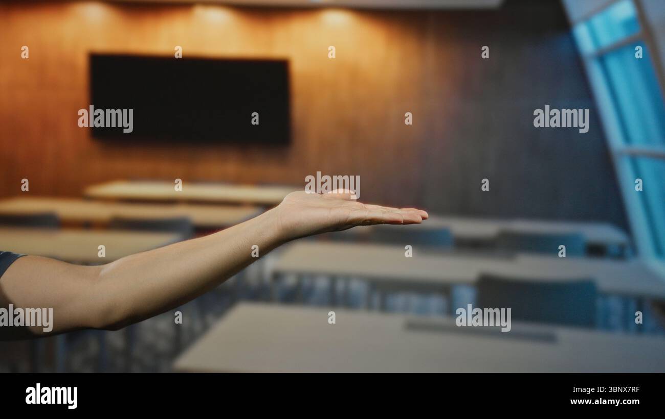 Man extending arm with palm open in an empty university classroom ...