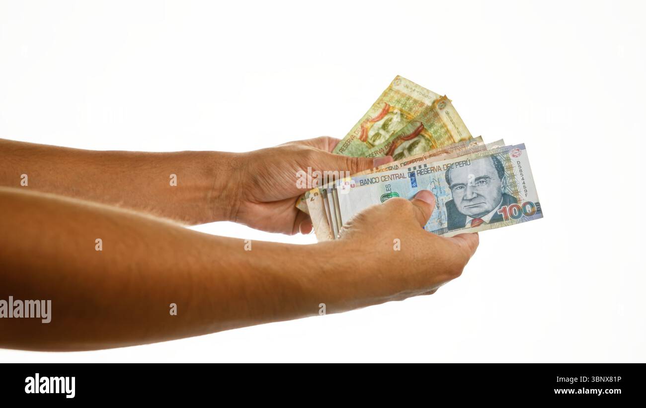 Hands holding peruvian soles in close-up on a white background ...