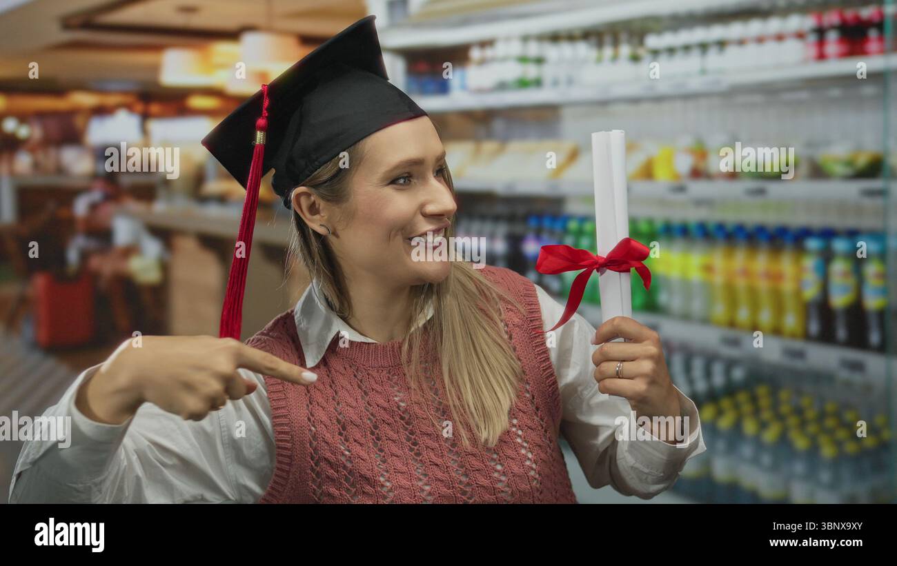 Young woman in graduation cap holding diploma and smiling indoors at a ...