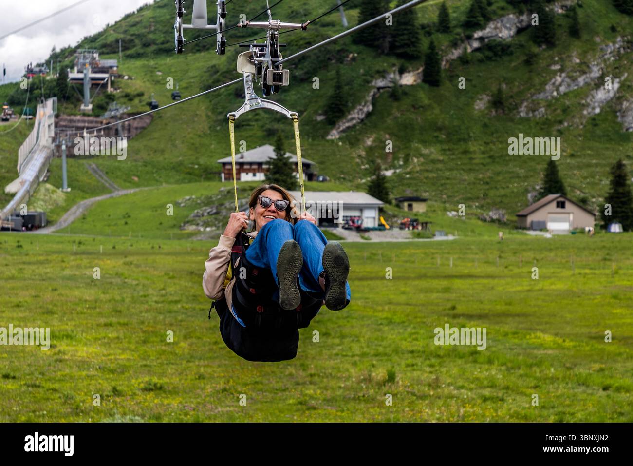 A smiling woman enjoys a thrilling ride on the zipline over Lake ...