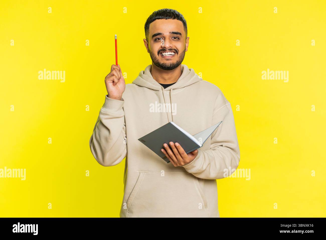Thoughtful journalist young Indian man making notes, writing down ...
