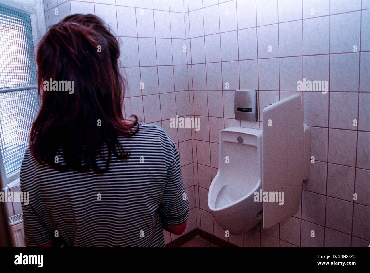 an urinal in a restroom, body hygiene and basic needs urinal in a mens ...