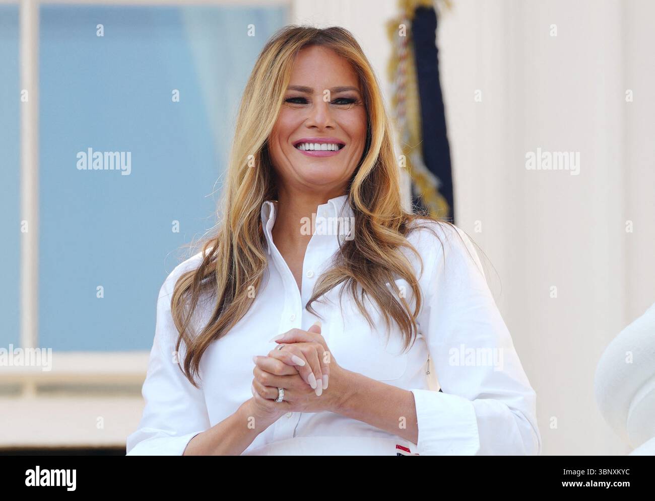 First Lady Melania Trump smiles as President Donald Trump speaks to ...