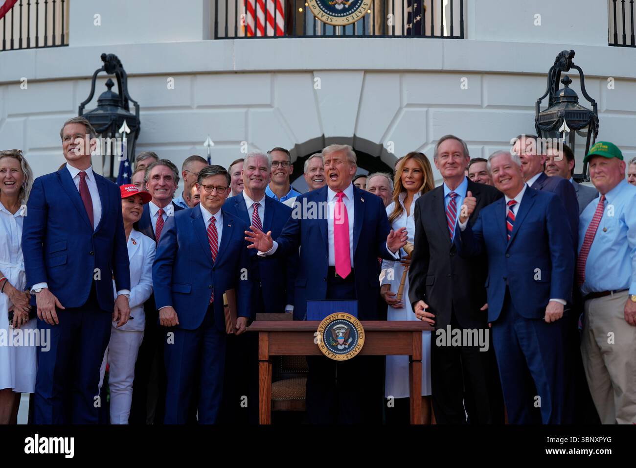 President Donald Trump stands on stage after signing his signature bill ...
