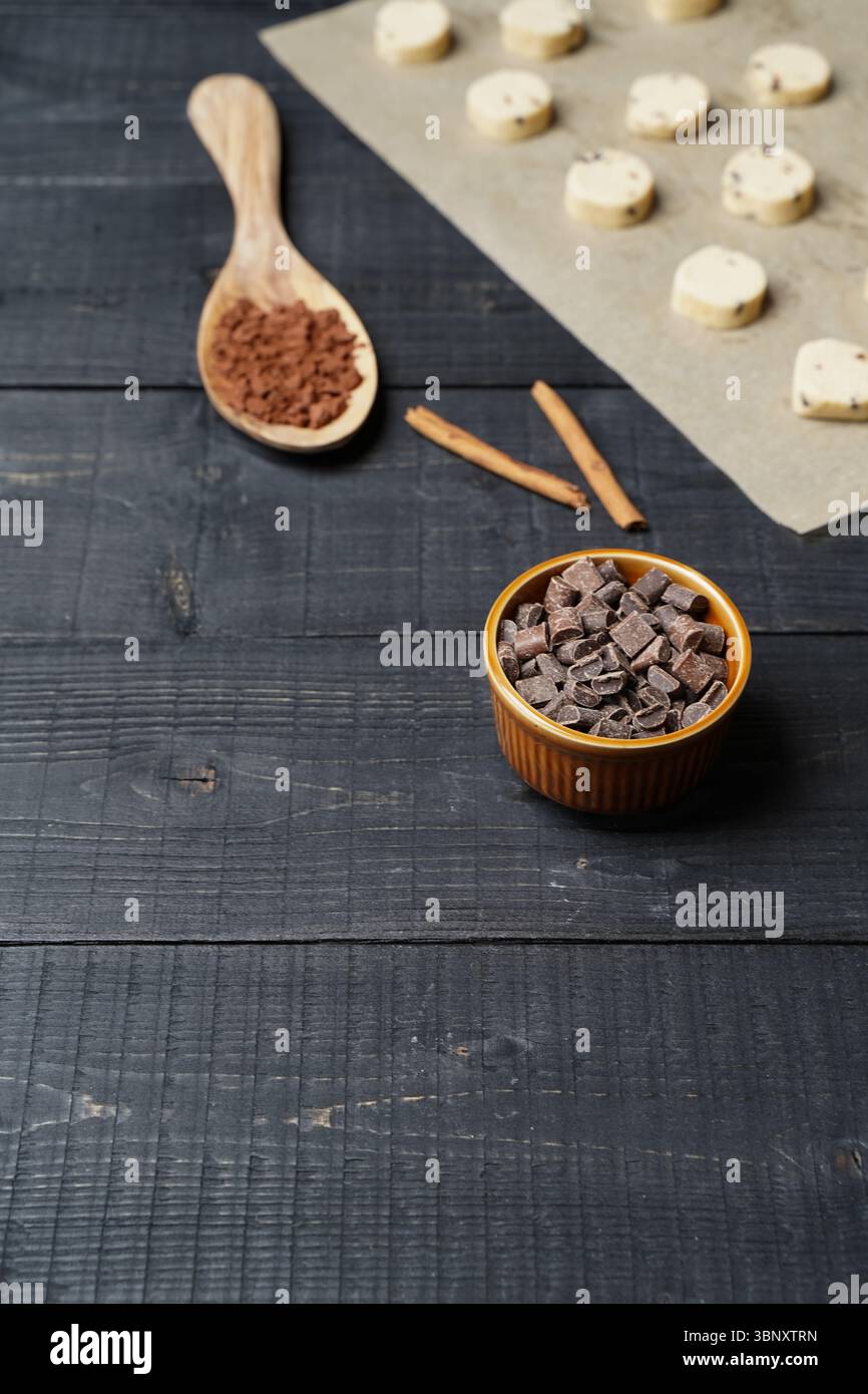 Vertical front view of cut cookie dough on baking paper with wooden ...