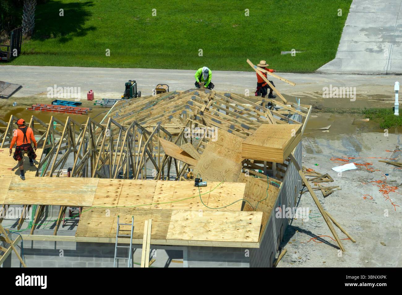 Builders working on roof construction of unfinished residential house ...