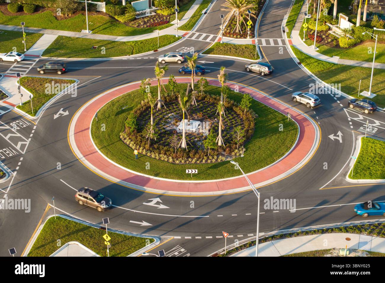 Roundabout crossroads on American city street with moving traffic cars ...