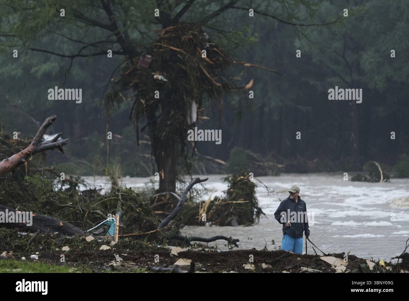A man surveys debris along the Guadalupe River after a flash flood ...