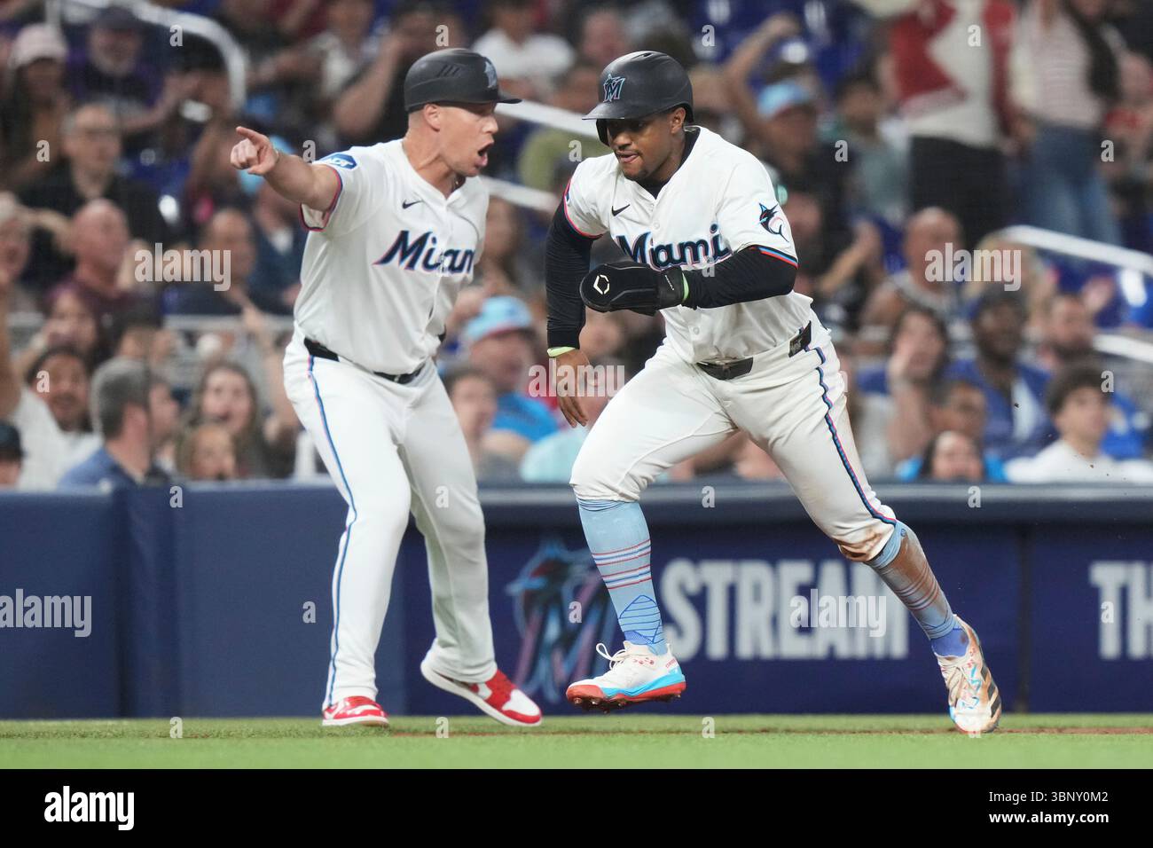 Miami Marlins' Xavier Edwards, right, runs past third base coach Blake ...