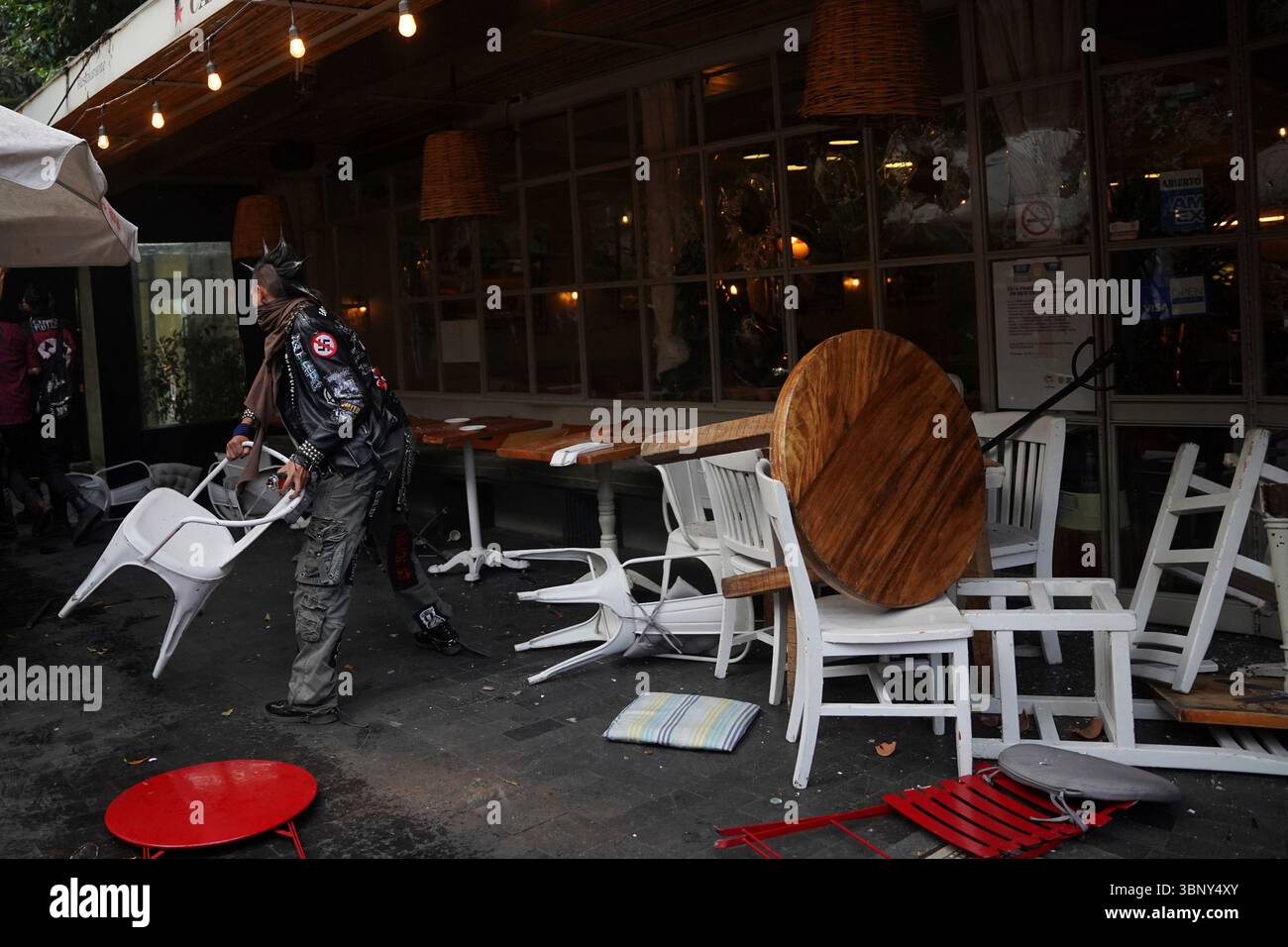 A demonstrator tosses a restaurant chair at the end of peaceful protest ...