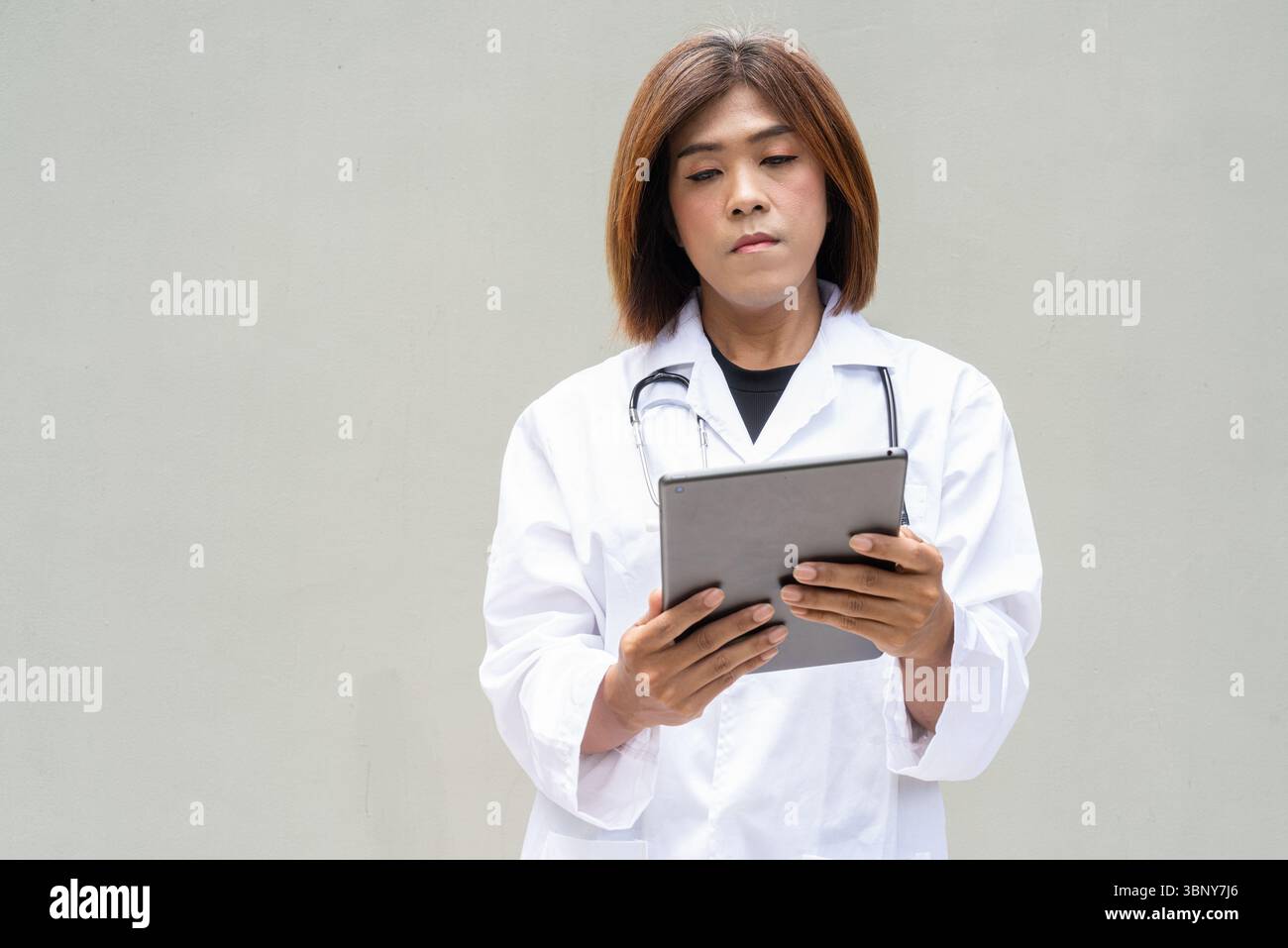 Portrait of Asian transgender non binary doctor with stethoscope ...