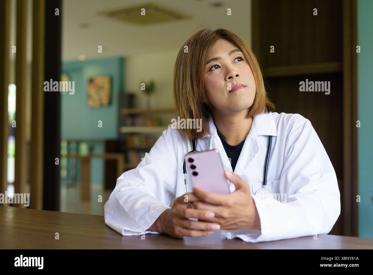 Portrait of Asian transgender non binary doctor with stethoscope ...