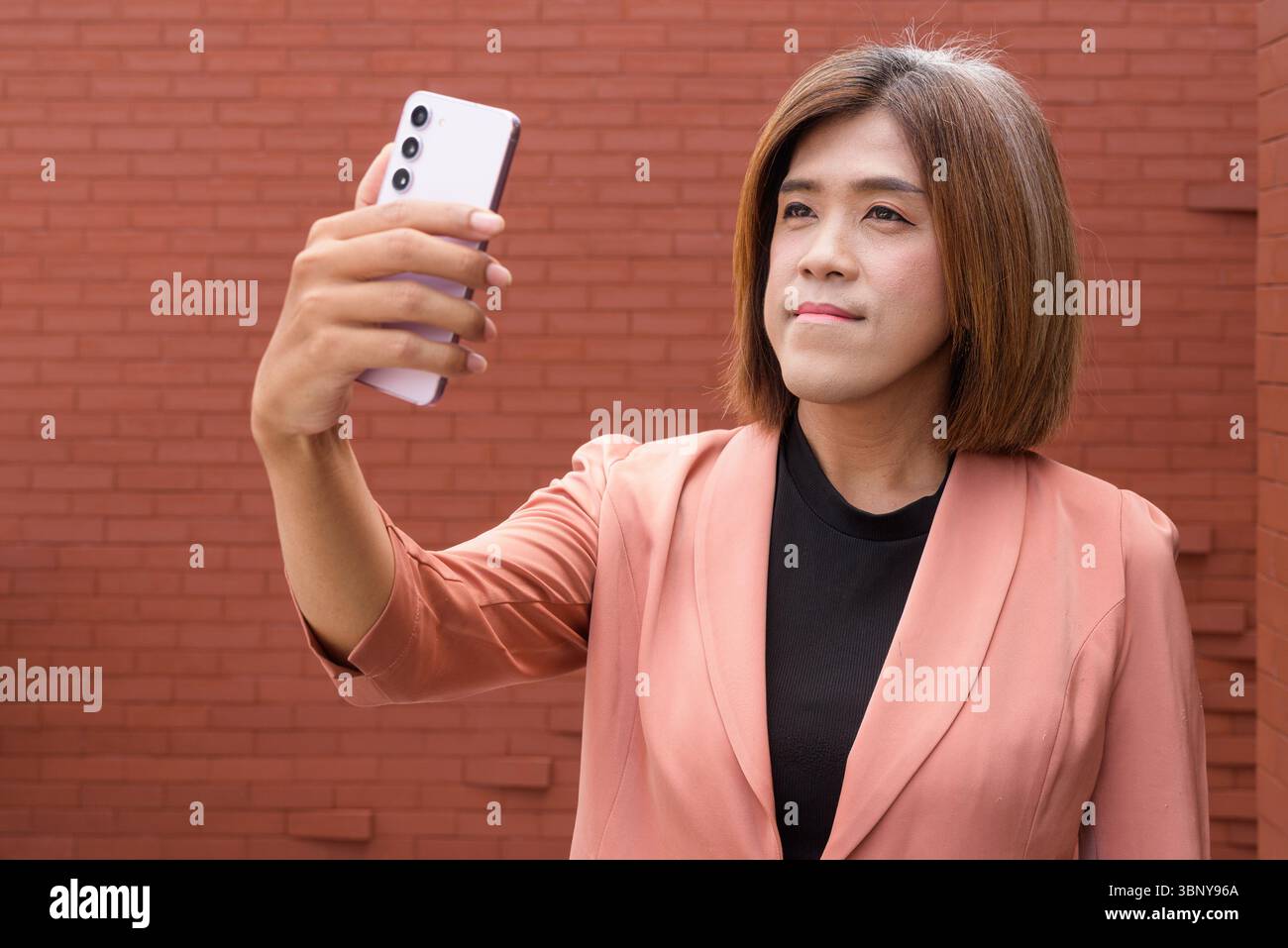 Confident Asian transgender non binary person in smart business attire ...