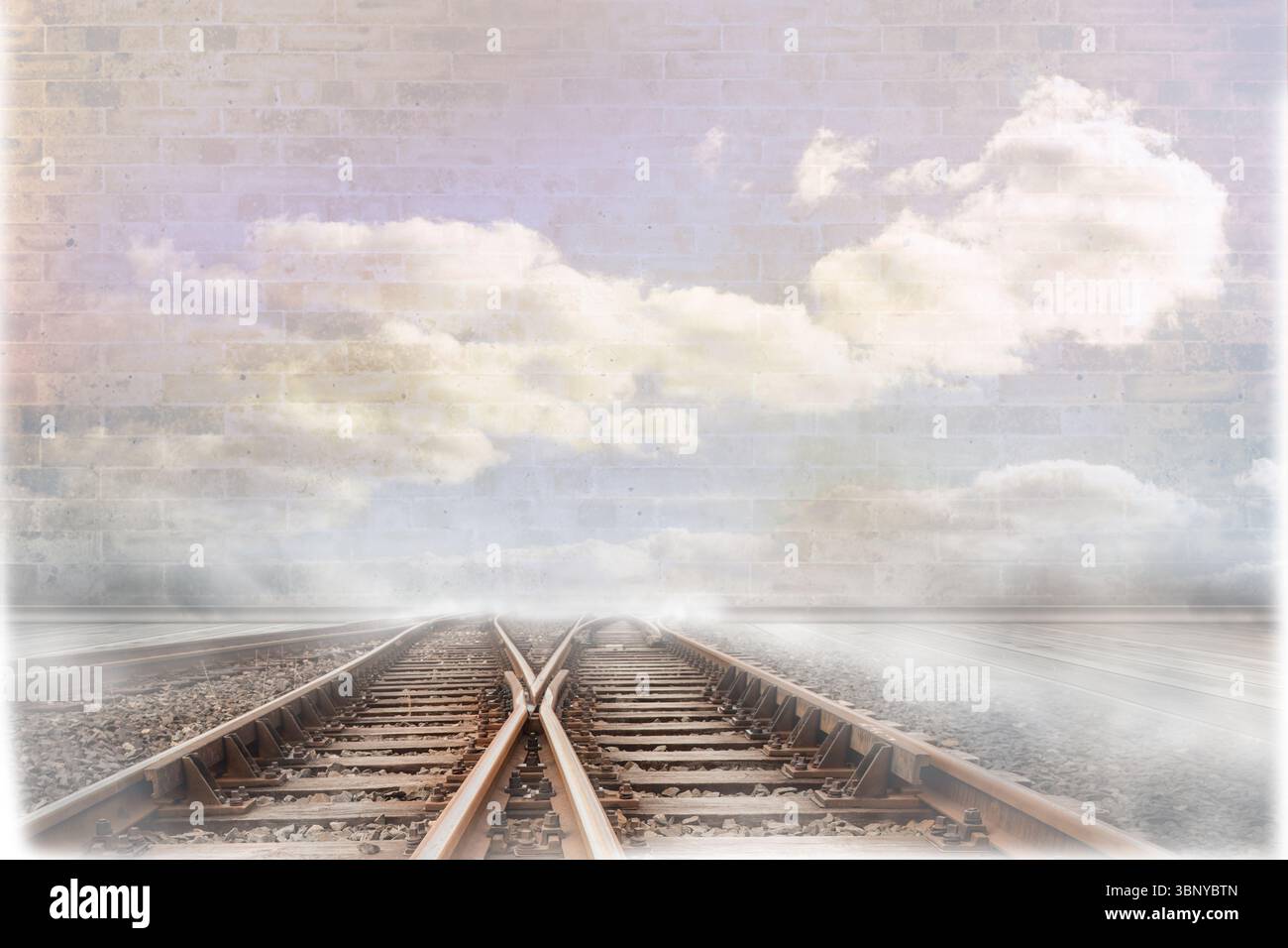 Train tracks leading to brick wall with clouds Stock Photo - Alamy