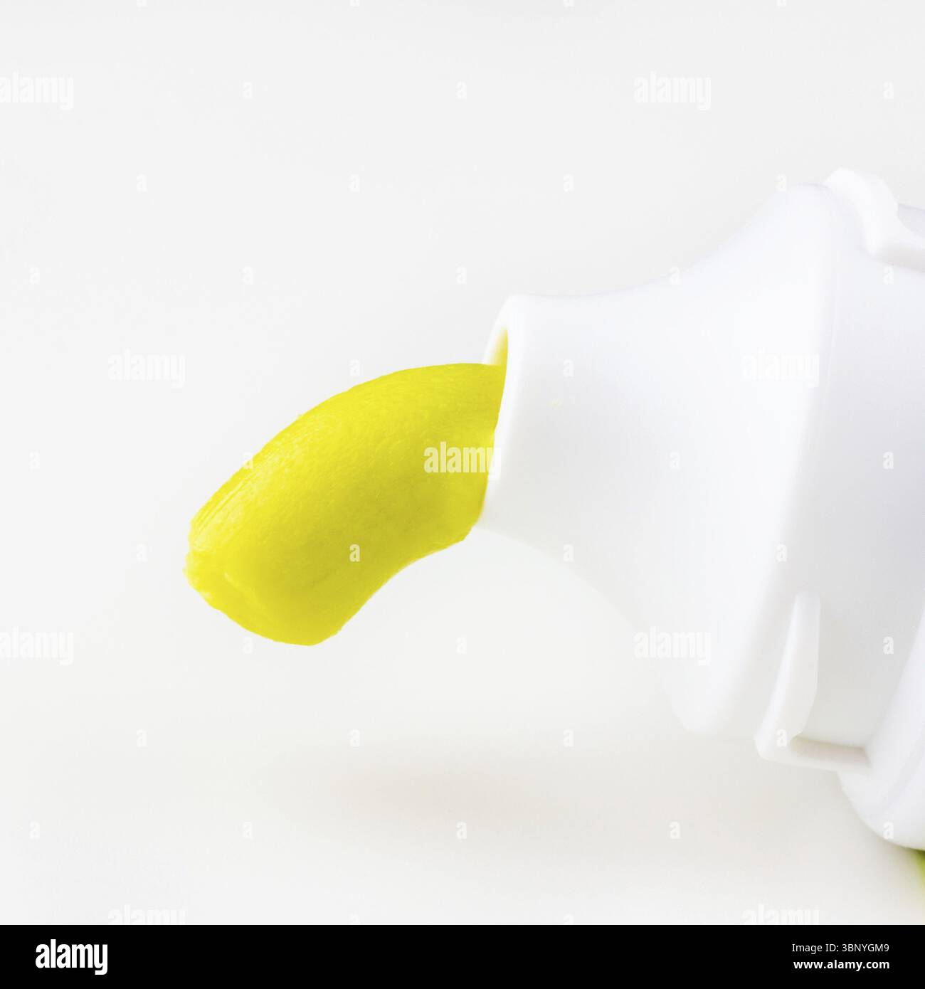 Green toothpaste is squeezed out of a tube of toothpaste on a white ...
