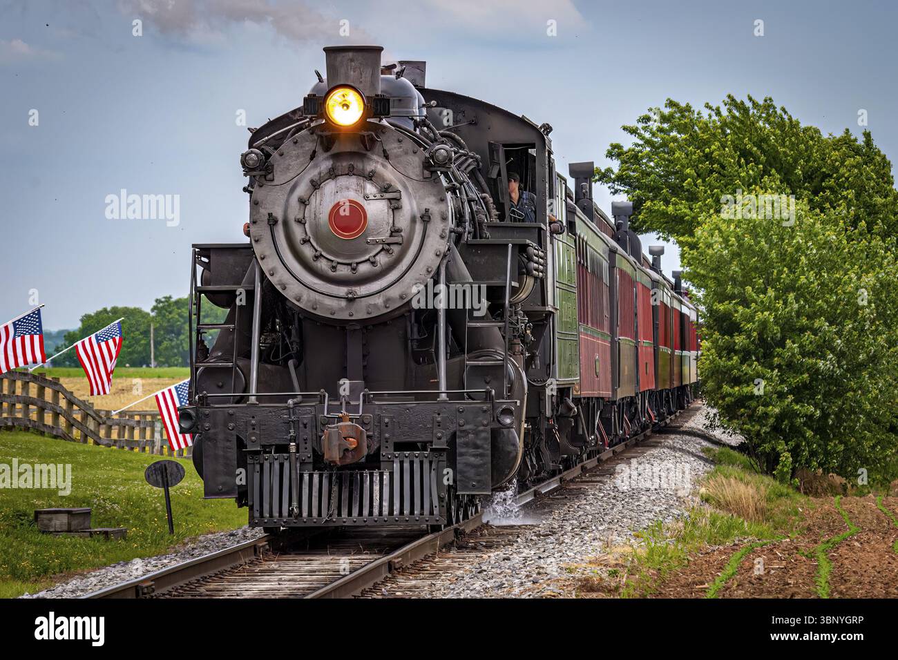 View of a Restored Steam Train Approaching Head-On With American Flags ...