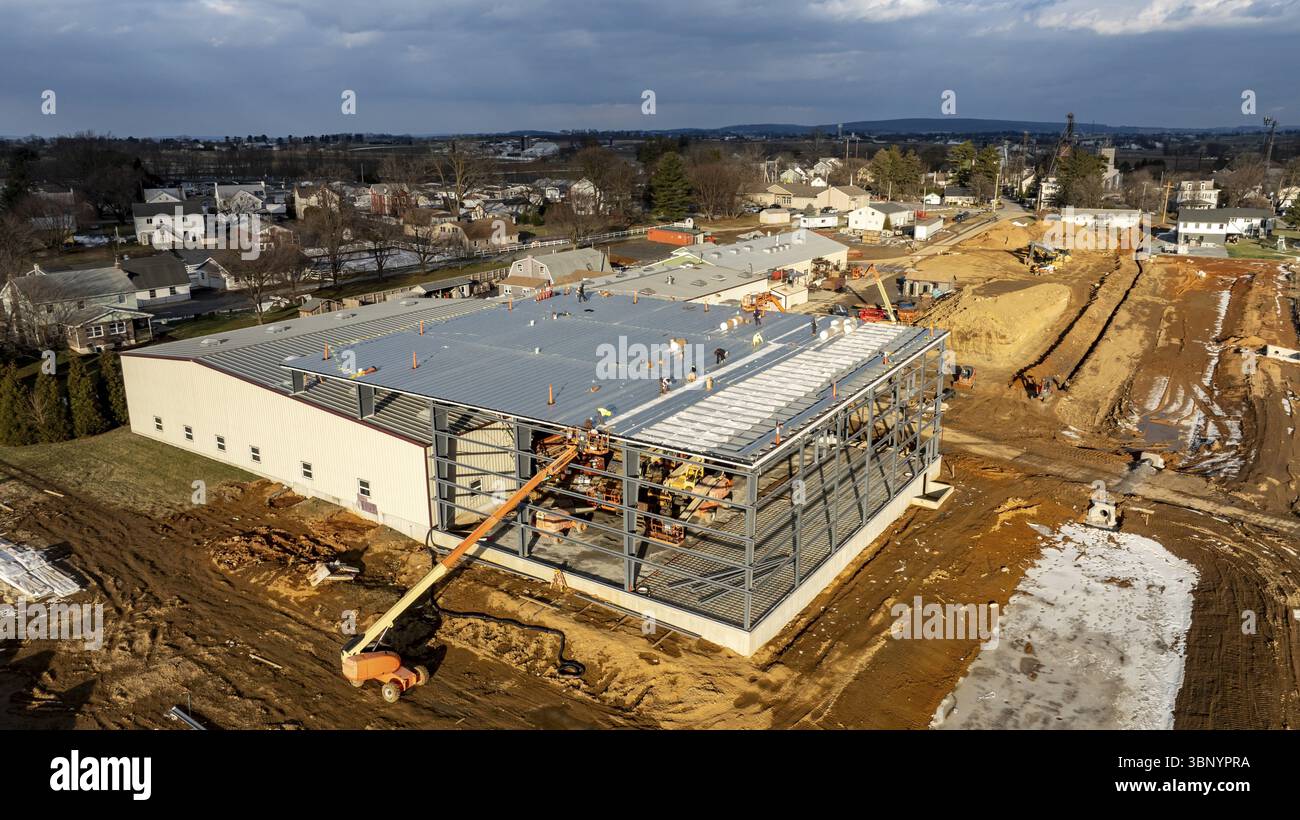 Work continues on a large commercial structure, with workers actively ...
