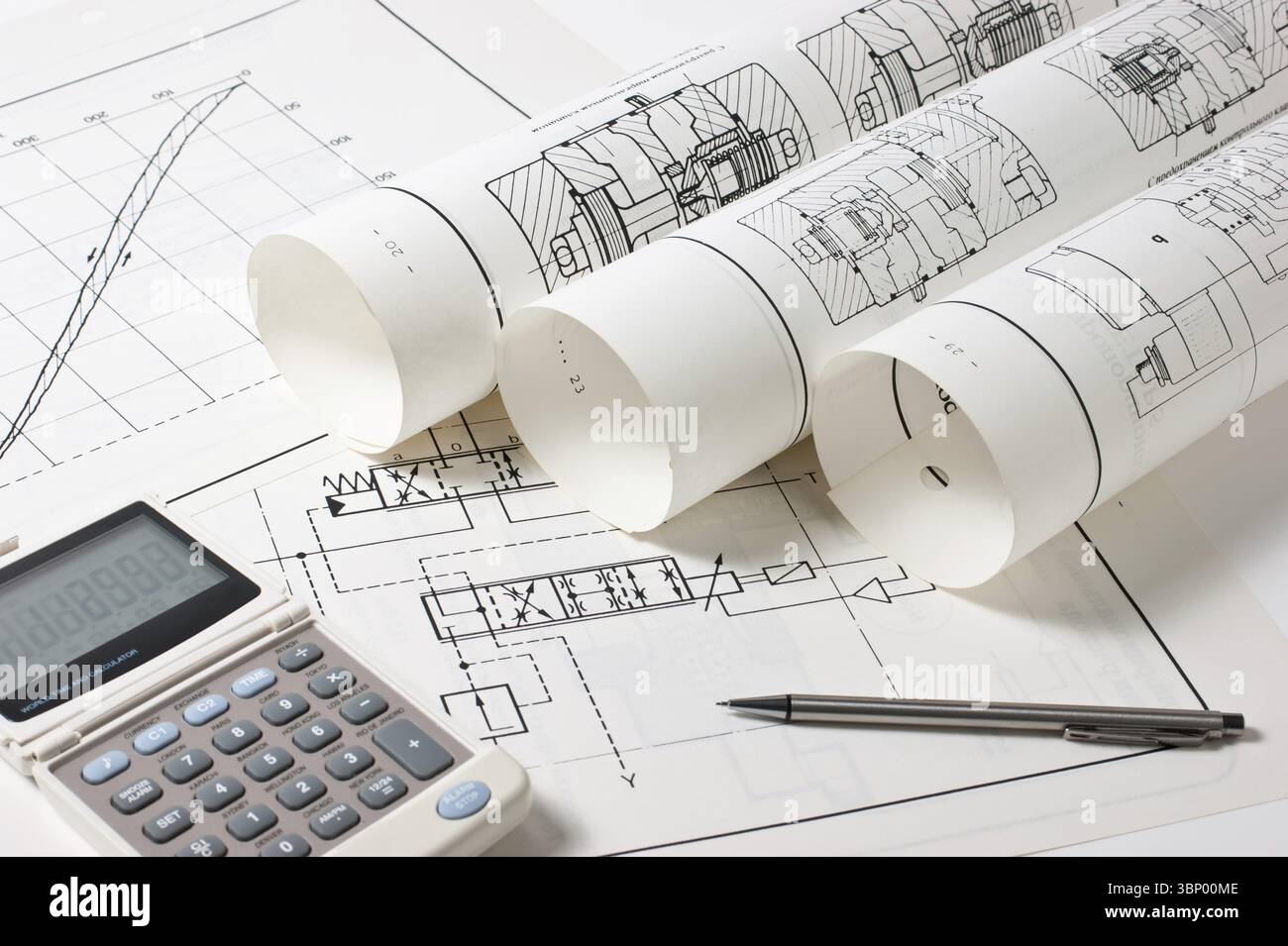 Rolled technical drawings and a calculator Stock Photo - Alamy
