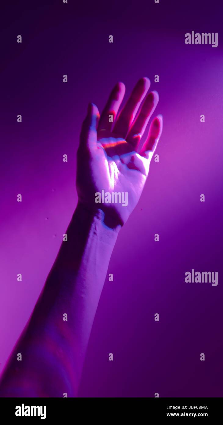 A Dramatic Purple-Illuminated Hand Reaching Out Against a Mysterious ...