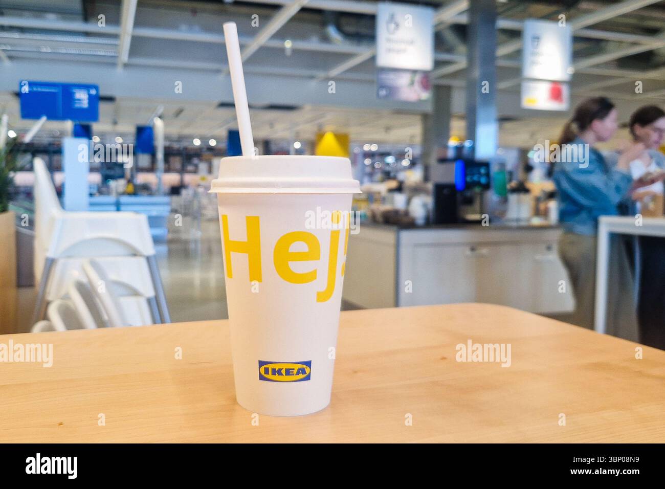 Tallinn, Estonia - June 19, 2025: Paper drink cup labeled “Hej” with the IKEA logo at IKEA food ...