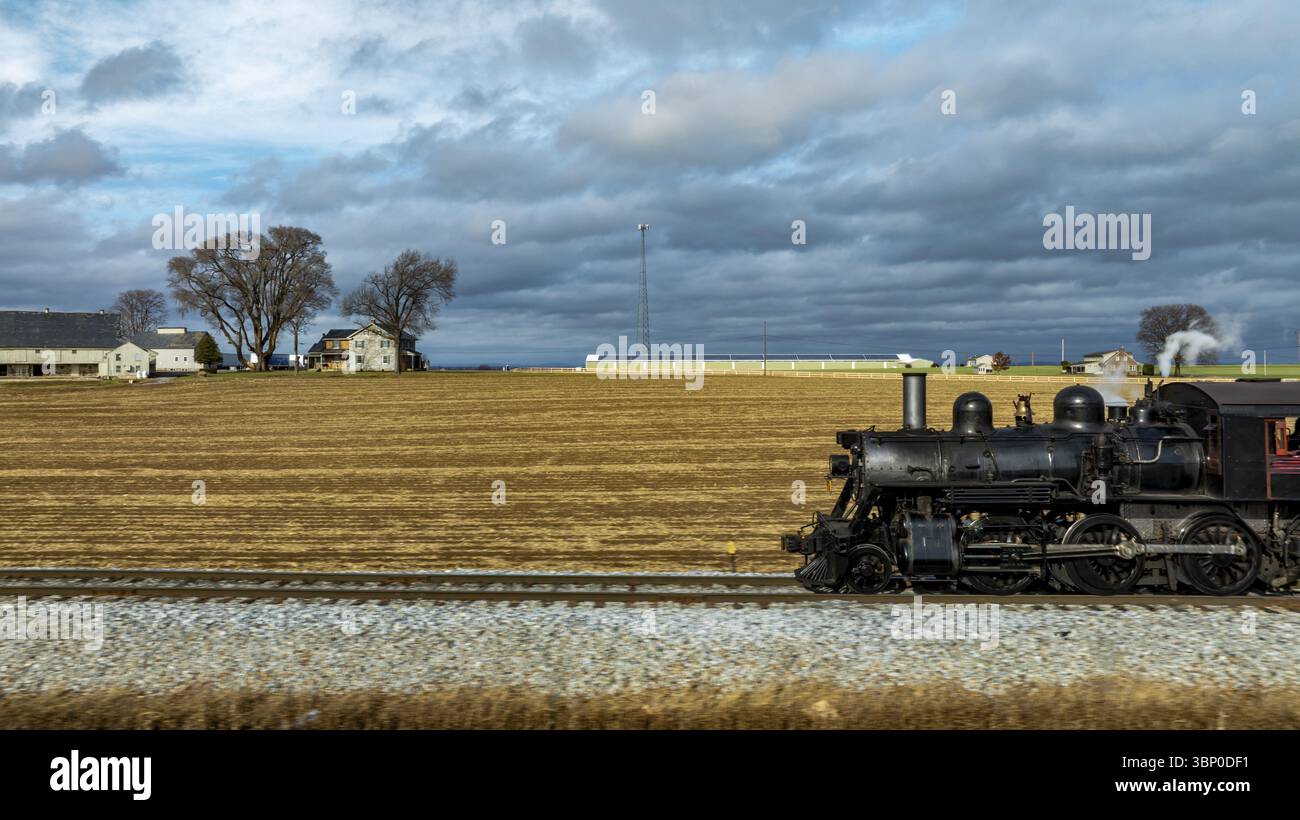 A vintage steam locomotive moves gracefully along the tracks while ...