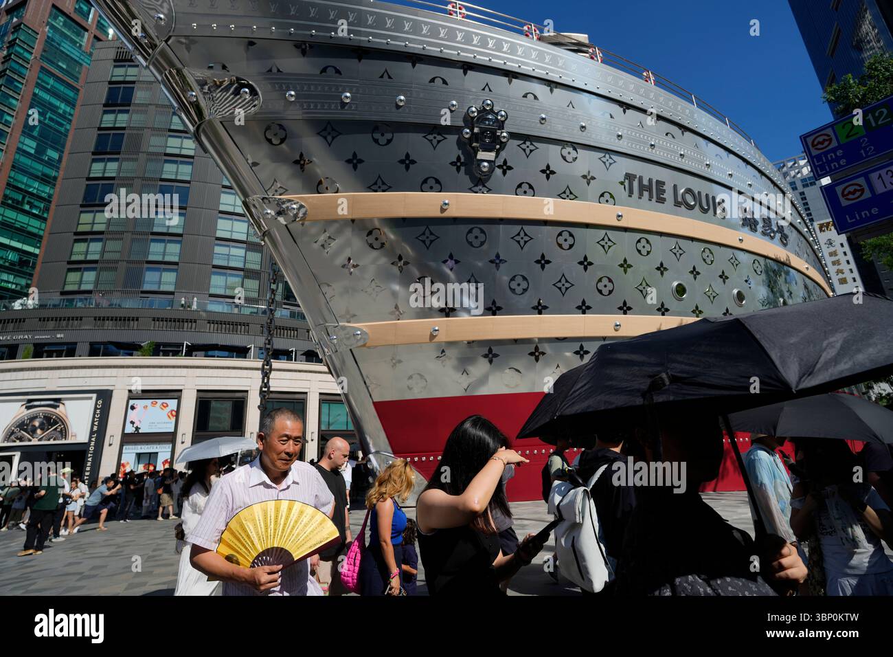 A man with a fan past Louis Vuitton's ship-shaped store 'The Louis' in ...