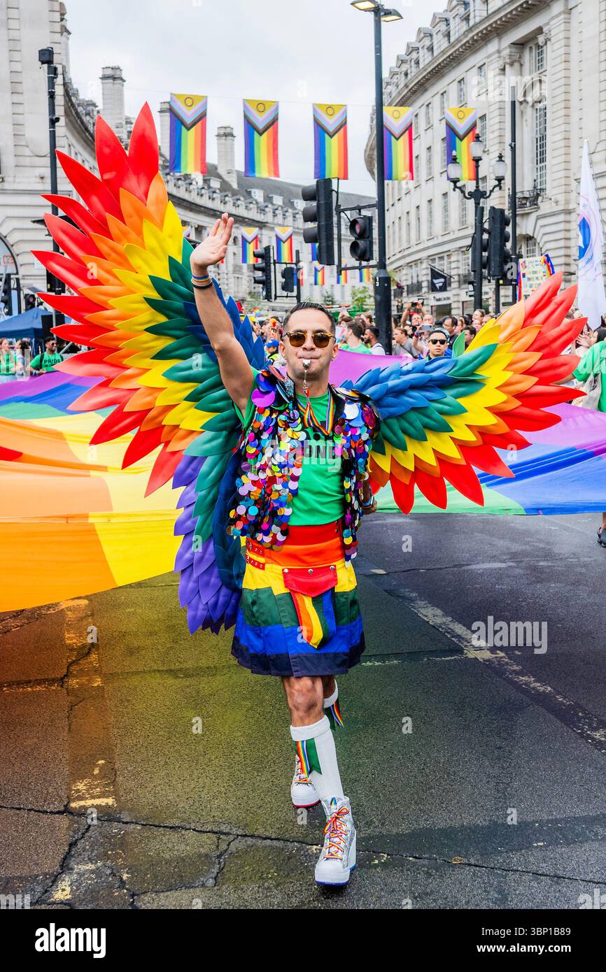 London, UK. 5th July, 2025. The giant rainbow pride flag is led by an ...