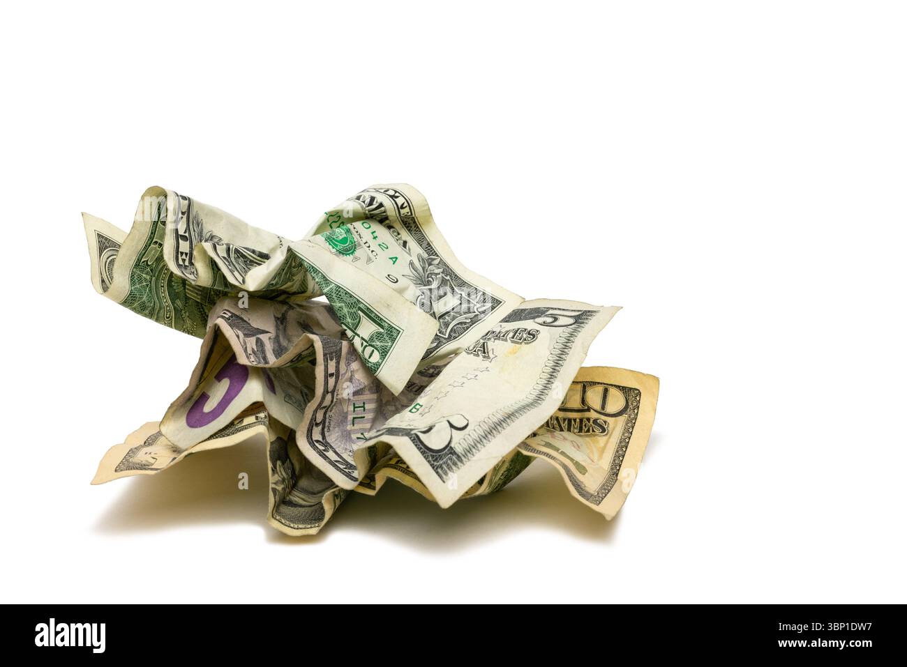 A pile of crumpled up dollars bills consisting of a one, five, and ten ...