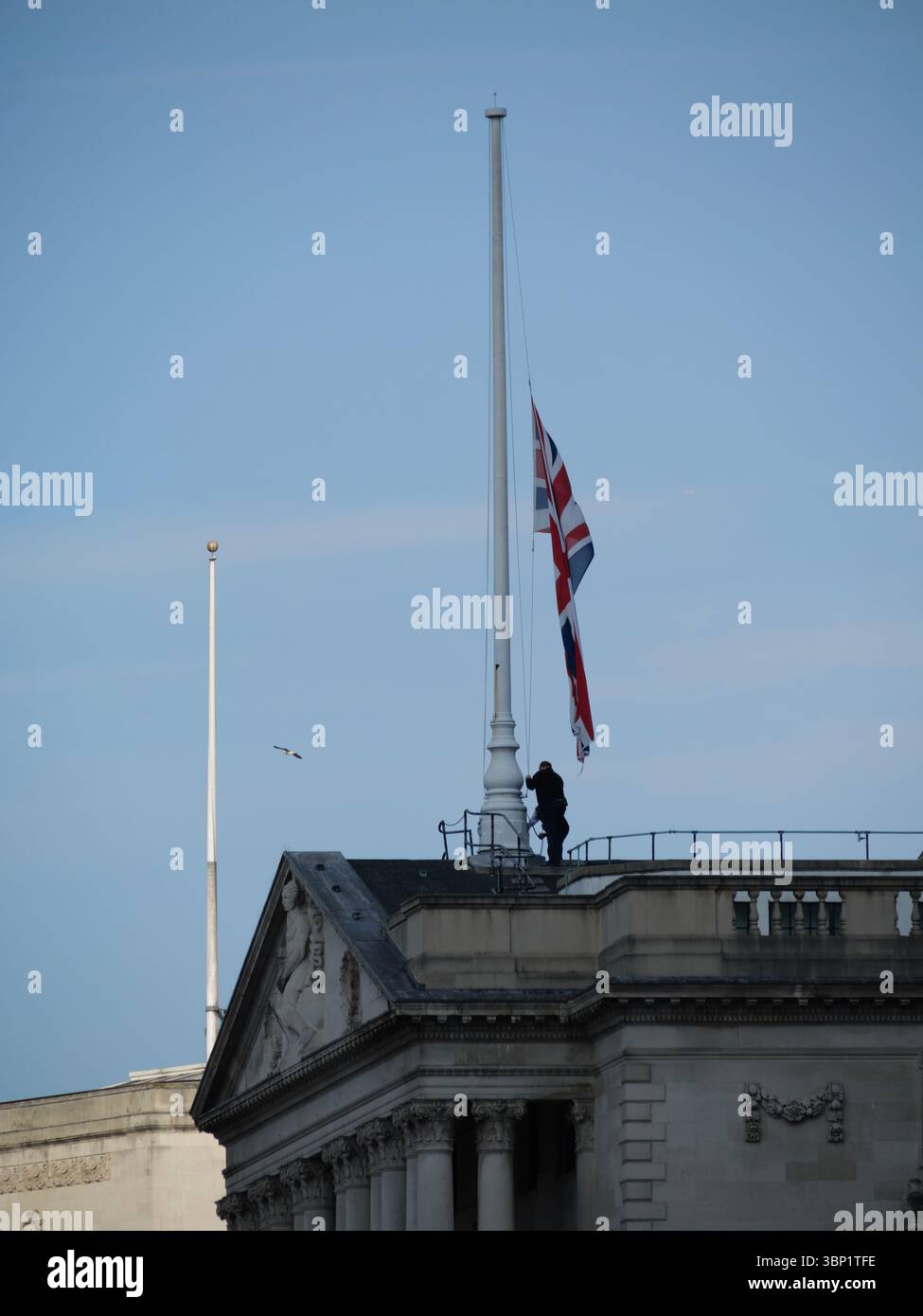 A member of staff raises the Union Flag outside the Bank of England ...