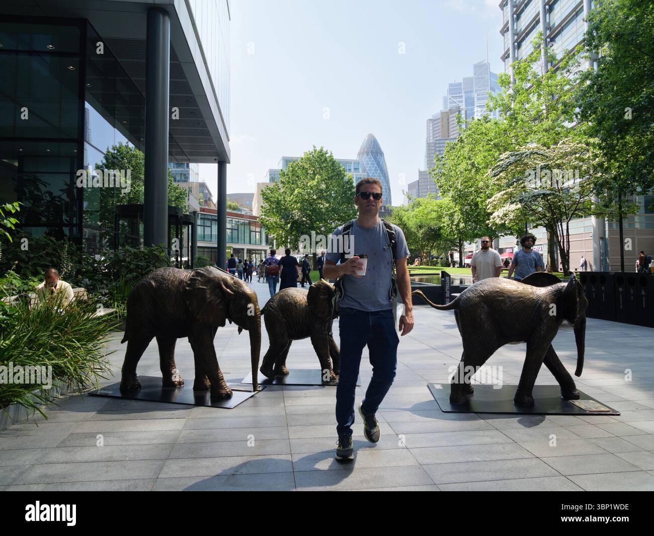 A commuter walks past life-sized bronze elephants from the Herd of Hope ...