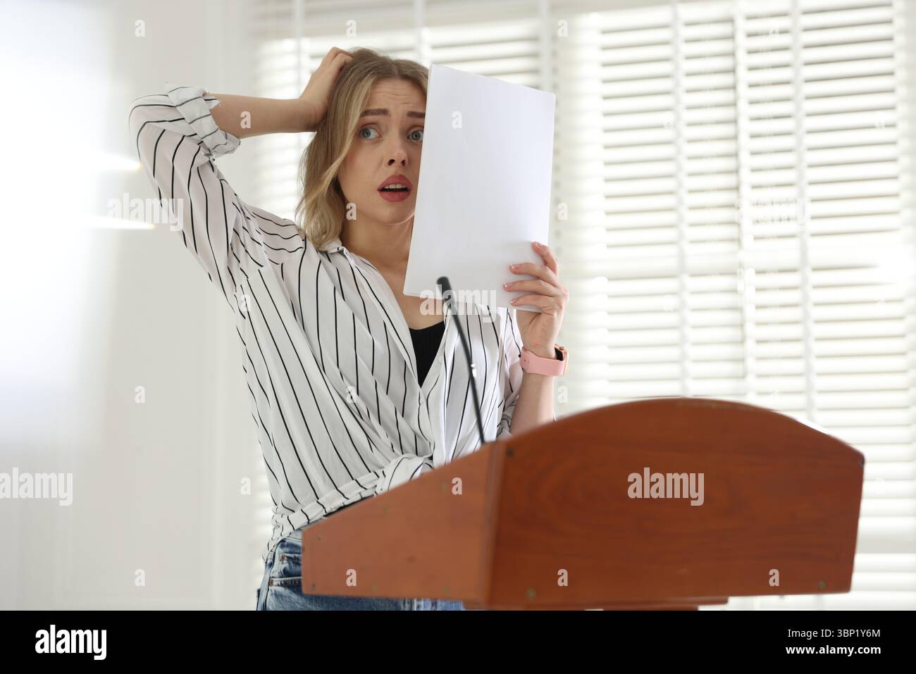 Fear of public speaking. Nervous woman with microphone at lectern ...