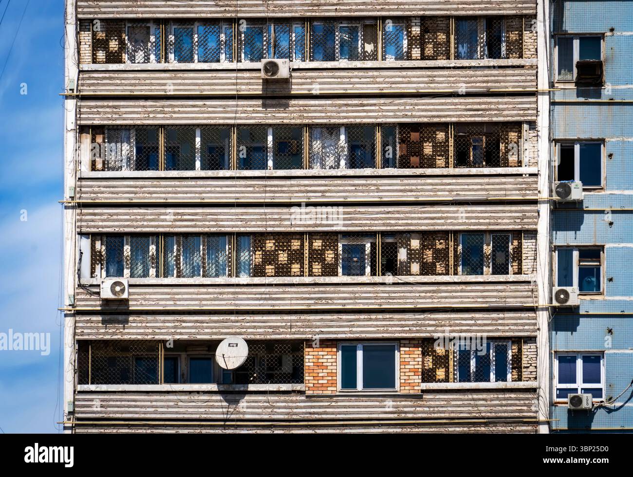 A close-up view of a weathered apartment building facade featuring ...