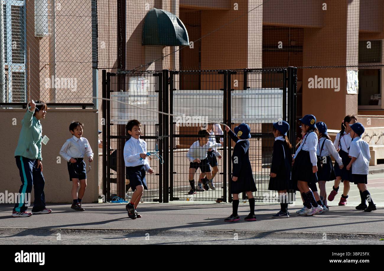 Group of Japanese elementary school students on the playground skipping ...