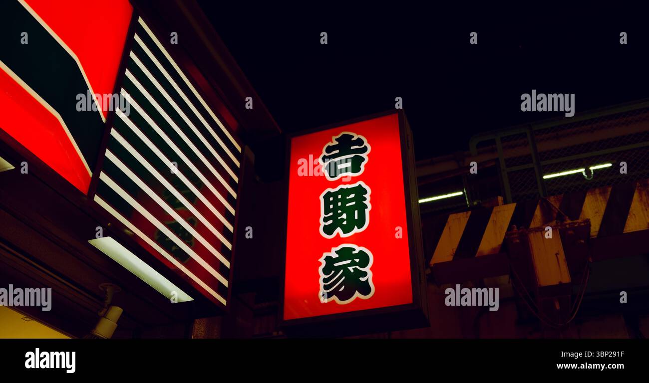 Illuminated Yoshinoya sign glowing at night, bold kanji characters ...