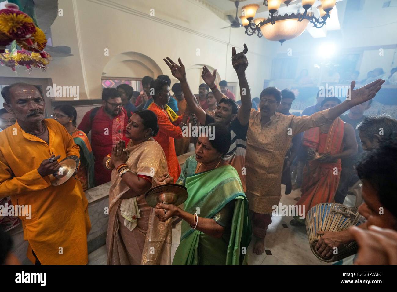 Hindu devotees dance and sing devotional songs in front of the Hindu ...