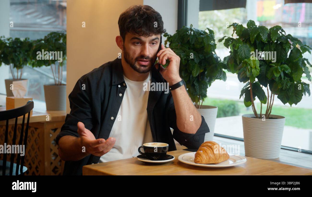 Angry nervous Caucasian man talking mobile phone cellphone quarrel ...