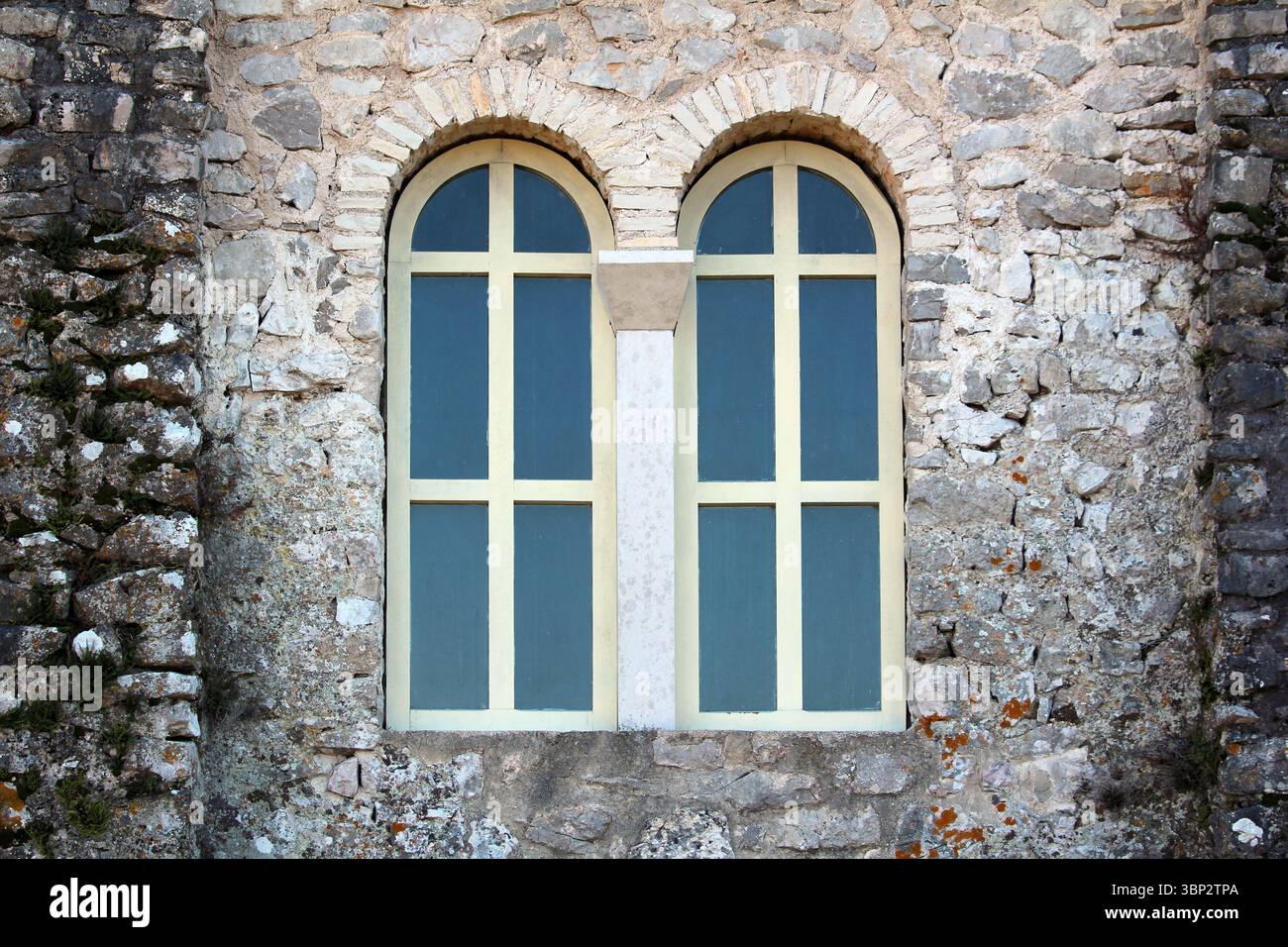 Two tall, arched windows with cream-colored wooden frames and cross ...