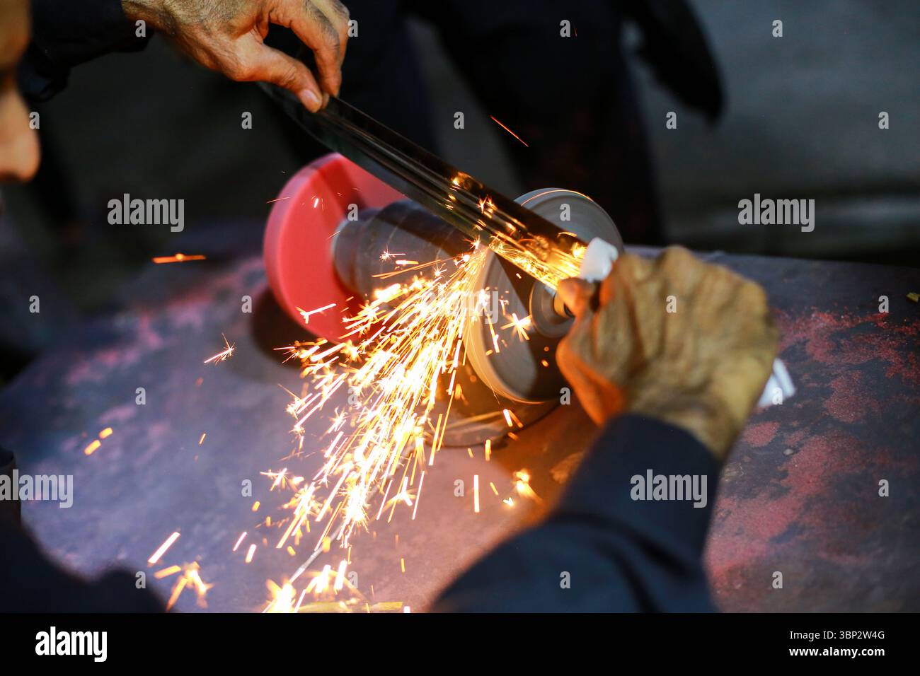 05 July 2025, Iraq, Karbala: A vendor sharpens knives for Iraqi Shiite ...