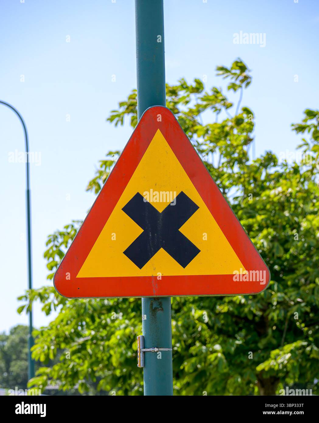A triangular caution sign is prominently displayed in an urban ...