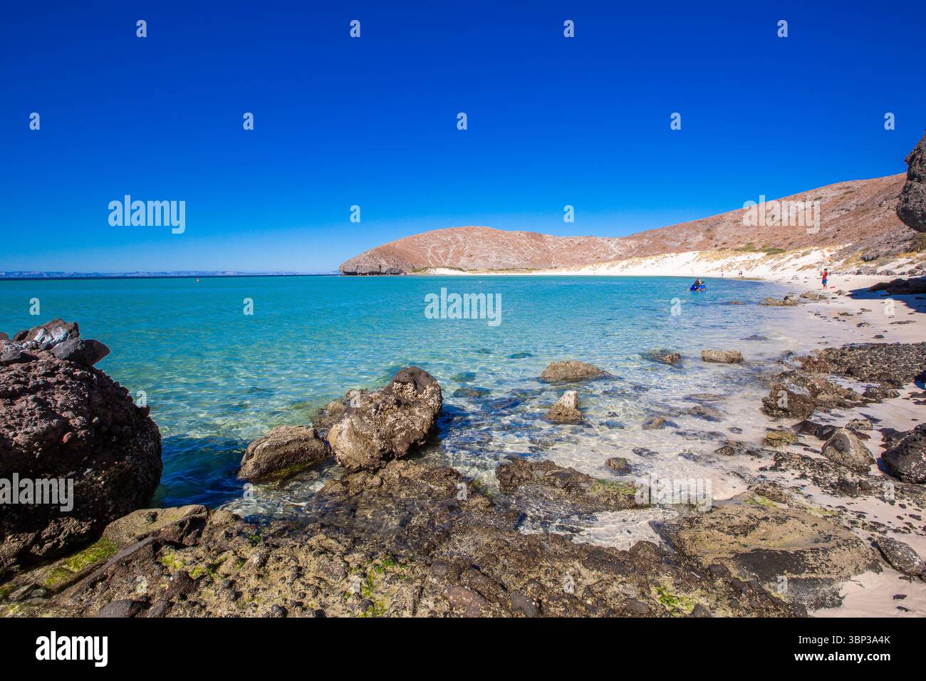 Crystal-clear shallow waters wash gently over the sandy and rocky ...