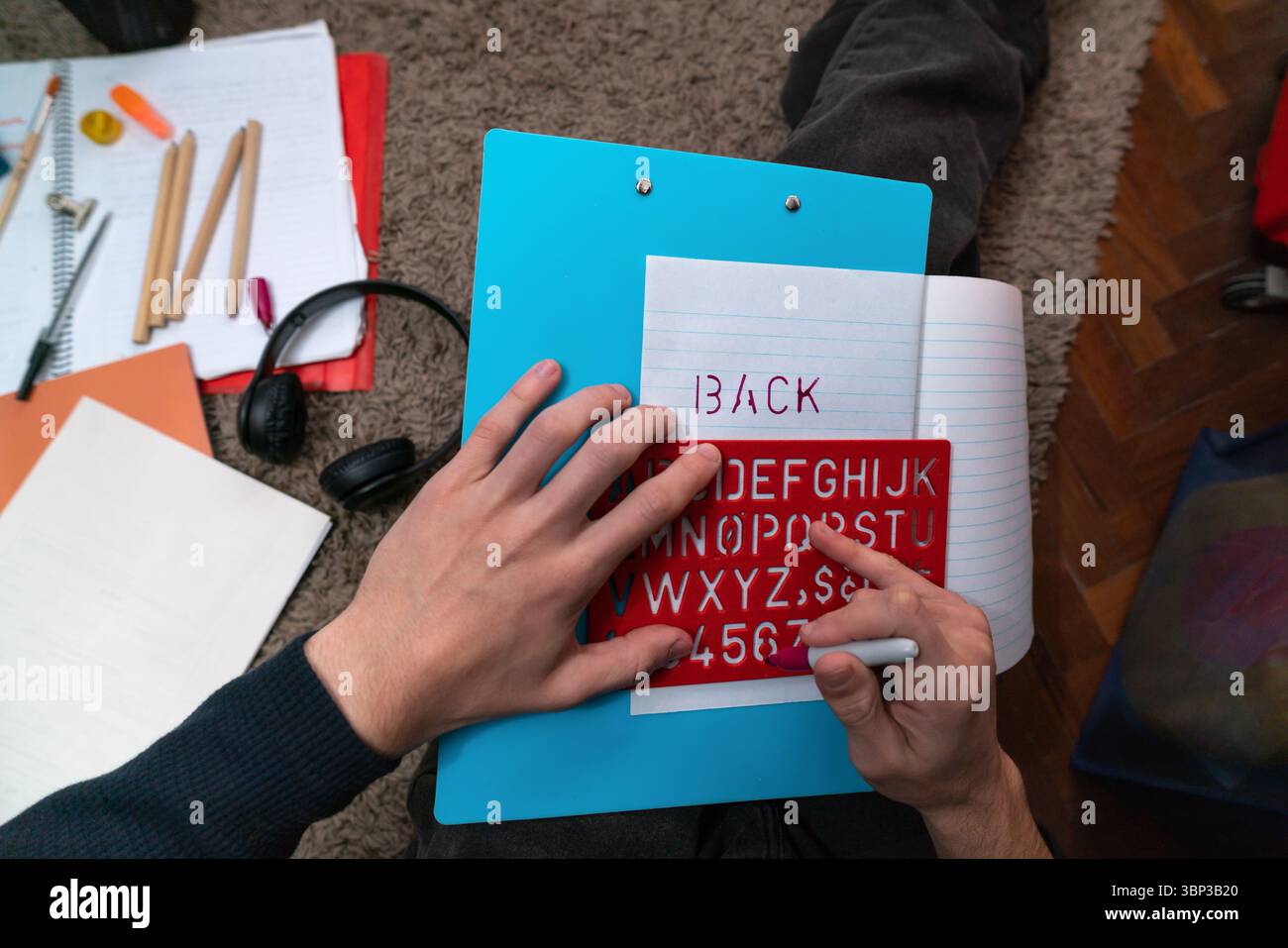 Student using alphabet stencil to write "Back" on notebook Stock Photo ...