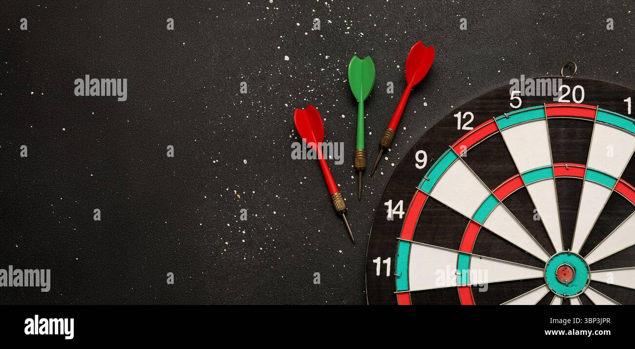 Darts and dartboard on black background with space for text, top view ...